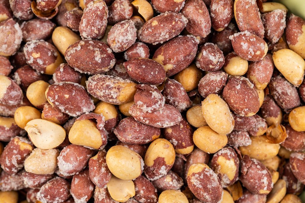 Raw Peanuts In A Whole Shell And Peanuts In A Broken Shell On A White Raw Peanuts In A Whole Shell And Peanuts In A Broken Shell On A White